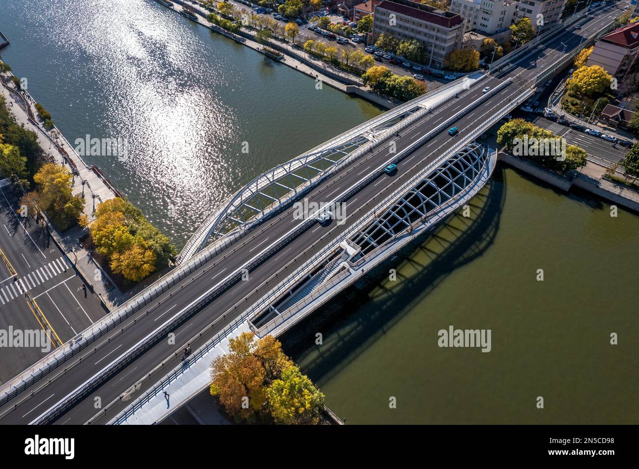 An aerial shot of a highway bridge over a river with shining water ...