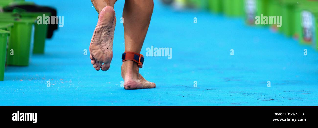 Aquathlon the transition zone, a race participant runs to put on ...