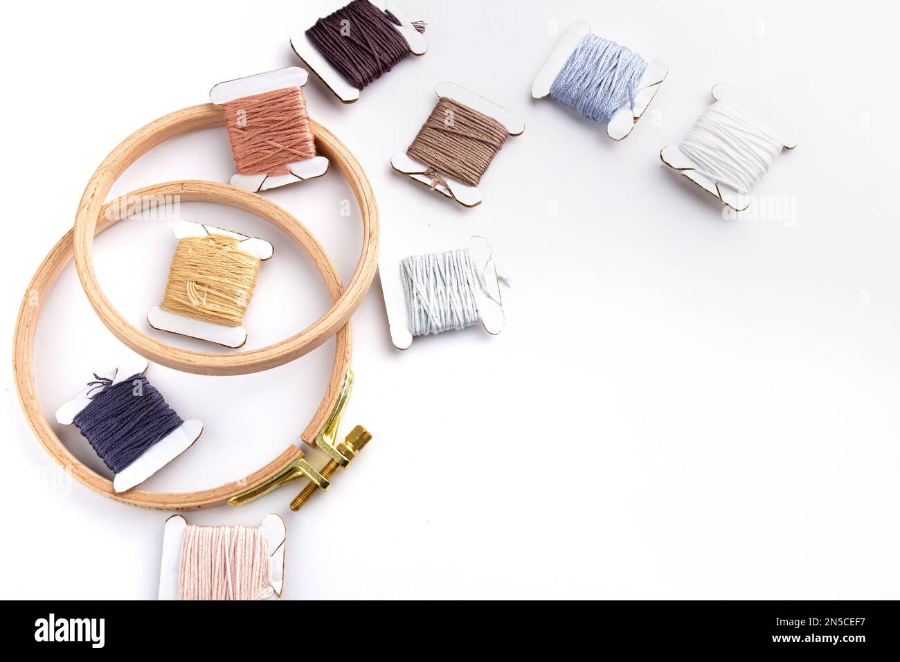 On a white background are cotton threads of different colors wound on ...