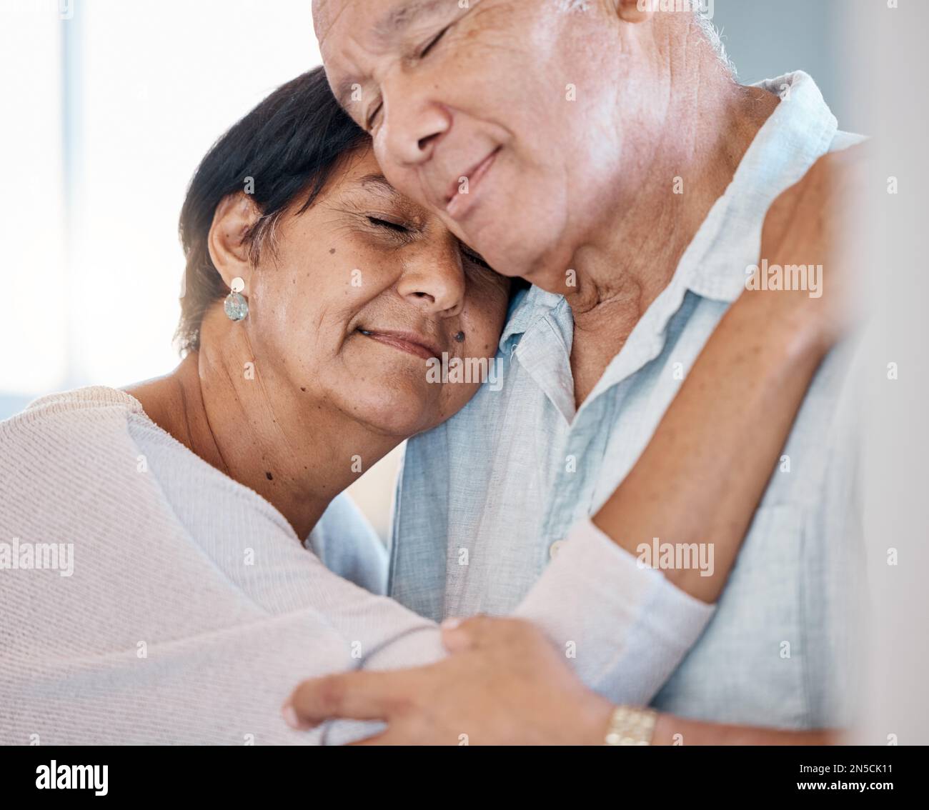 Calm senior couple hug with love, care and romance in home. Man, woman ...