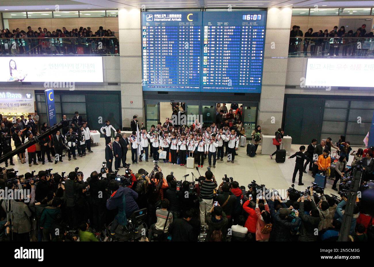 South Korean Sochi Winter Olympic athletes are surrounded by a pack of ...