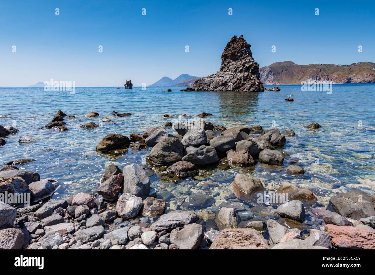 Volcanic bay with a view of the stack and Lipari and Salina in the ...