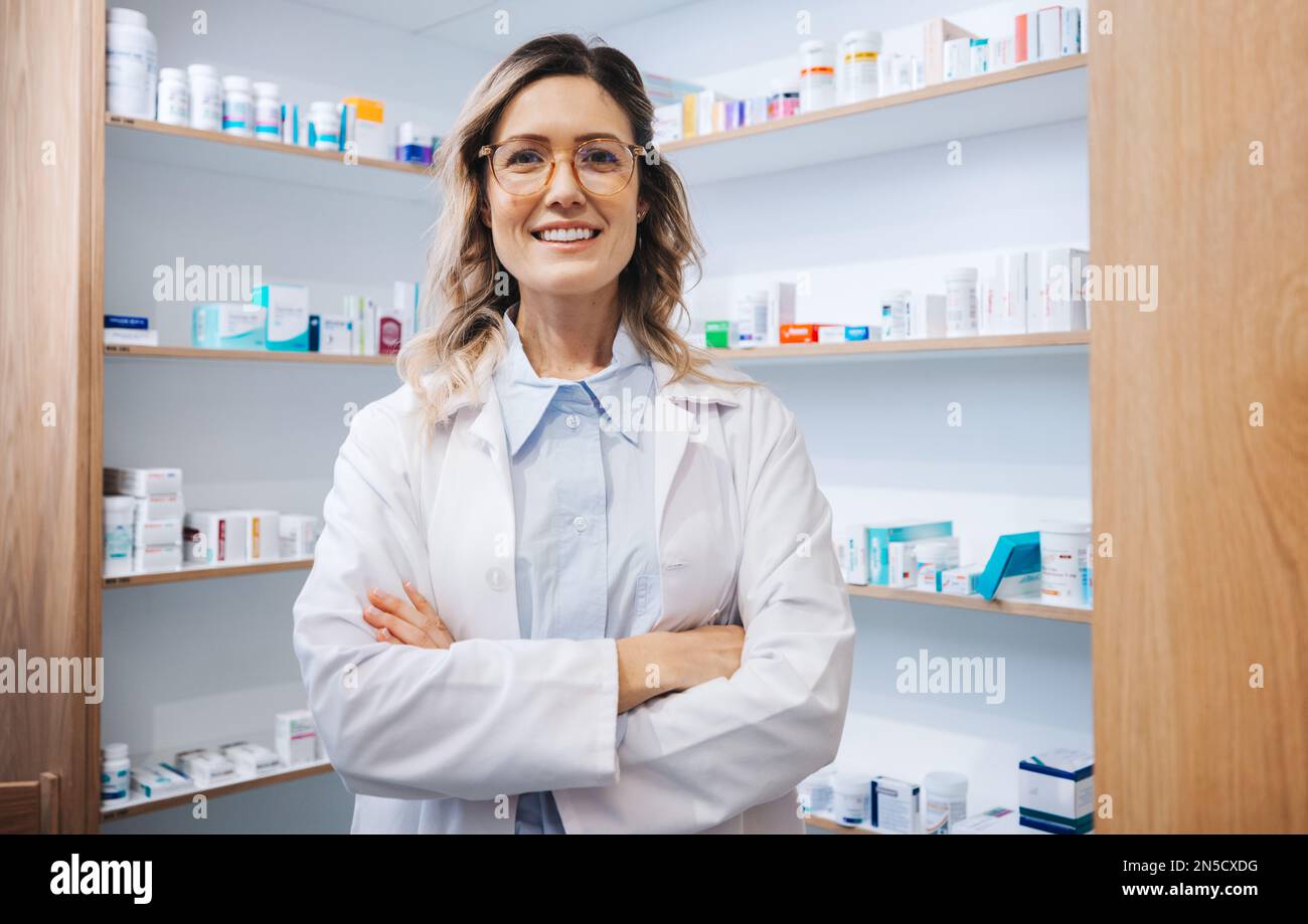 Portrait of a female pharmacist standing in a drug store. Female ...