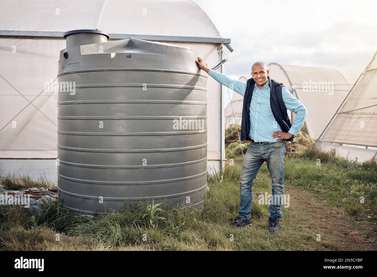 Man, portrait and water tank in farming liquid or soil hydration for ...