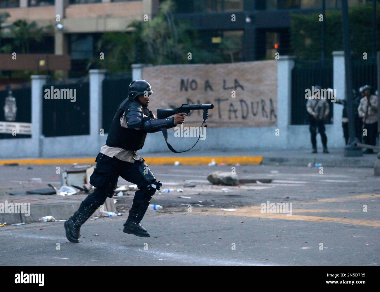 A policeman fire a tear gas canister to demonstrators during an anti ...