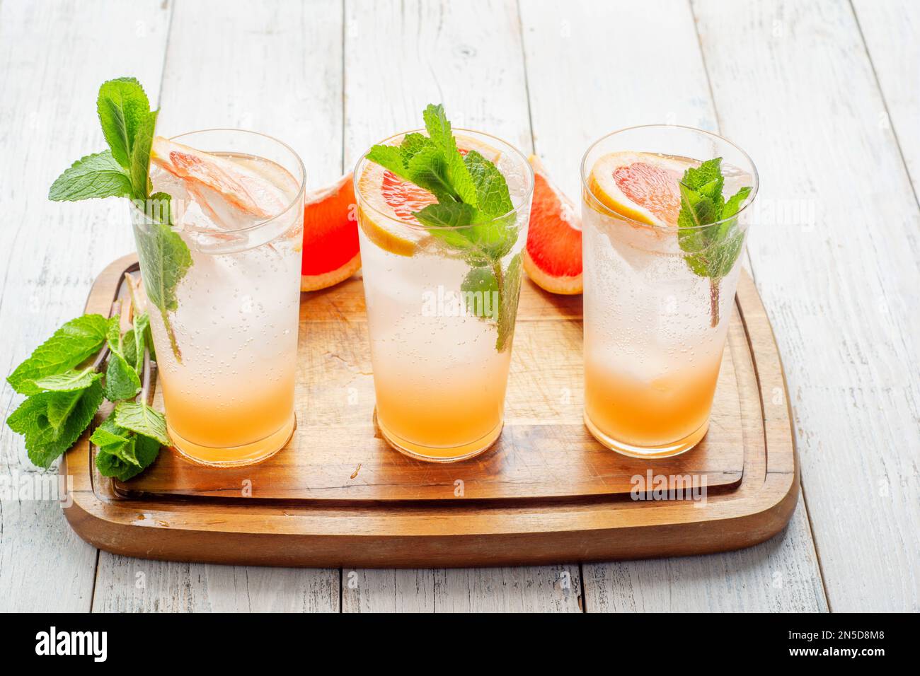Summer refreshing fruit drinks with ice on a grey kitchen board Stock ...