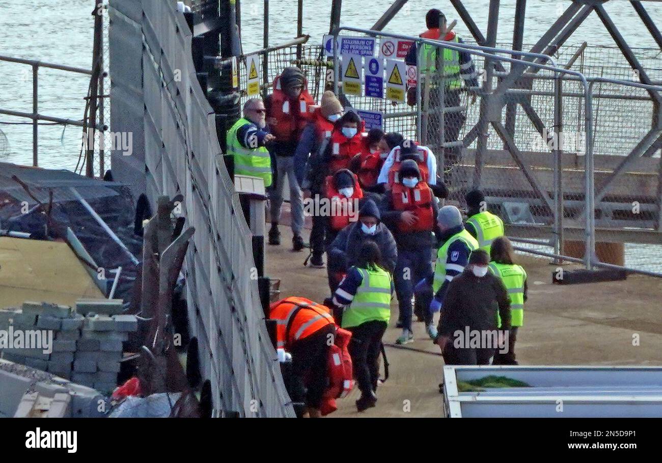 A group of people thought to be migrants walk through the immigration ...