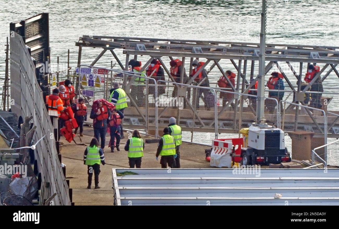 A group of people thought to be migrants walk through the immigration ...