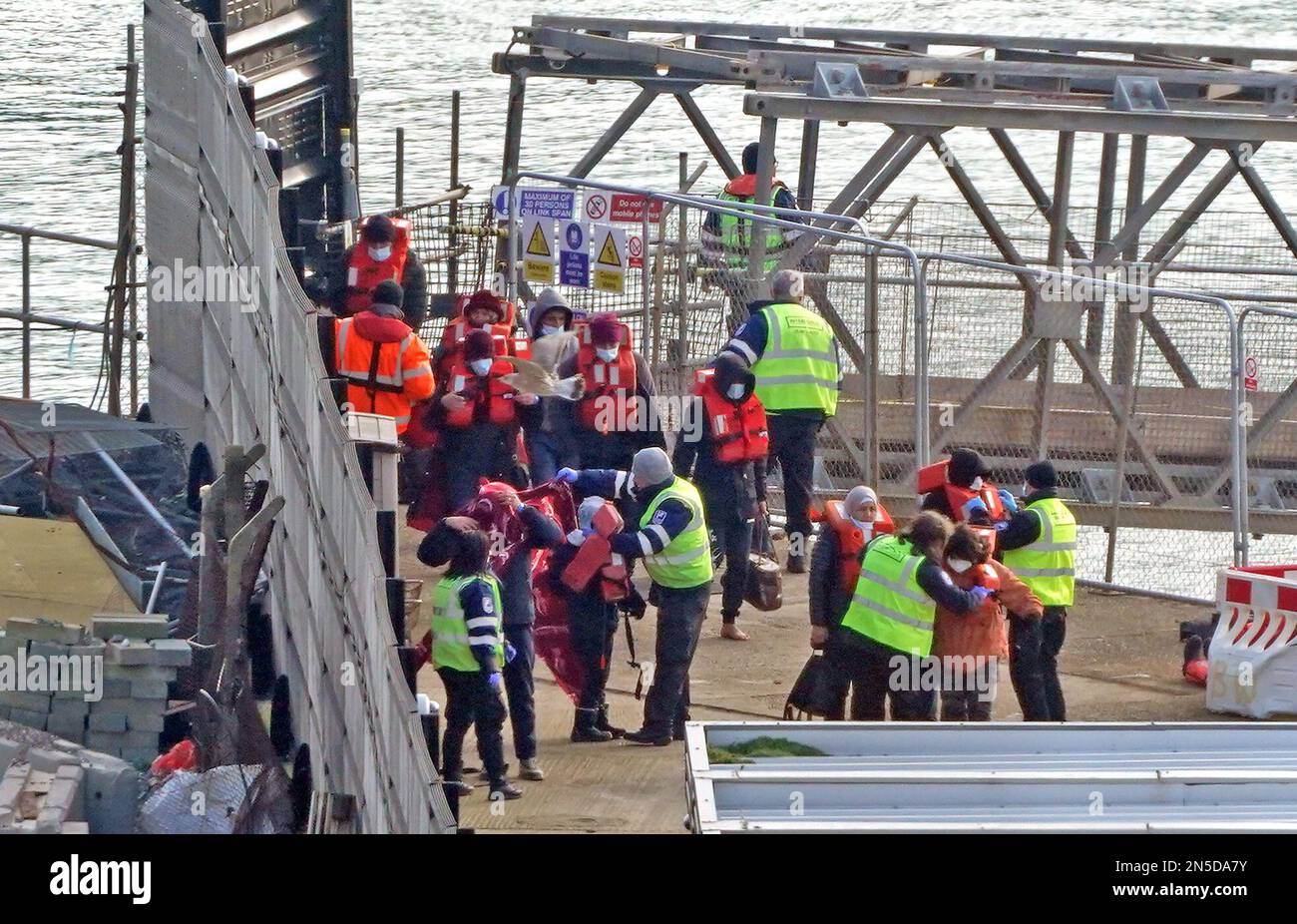A group of people thought to be migrants walk through the immigration ...