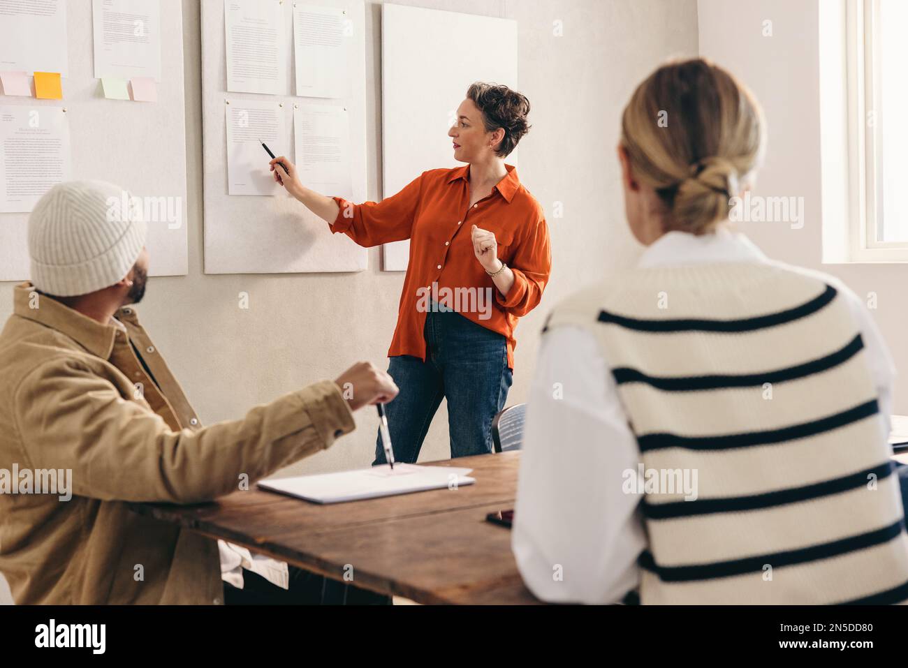 Mature businesswoman giving a presentation to her team during a meeting ...