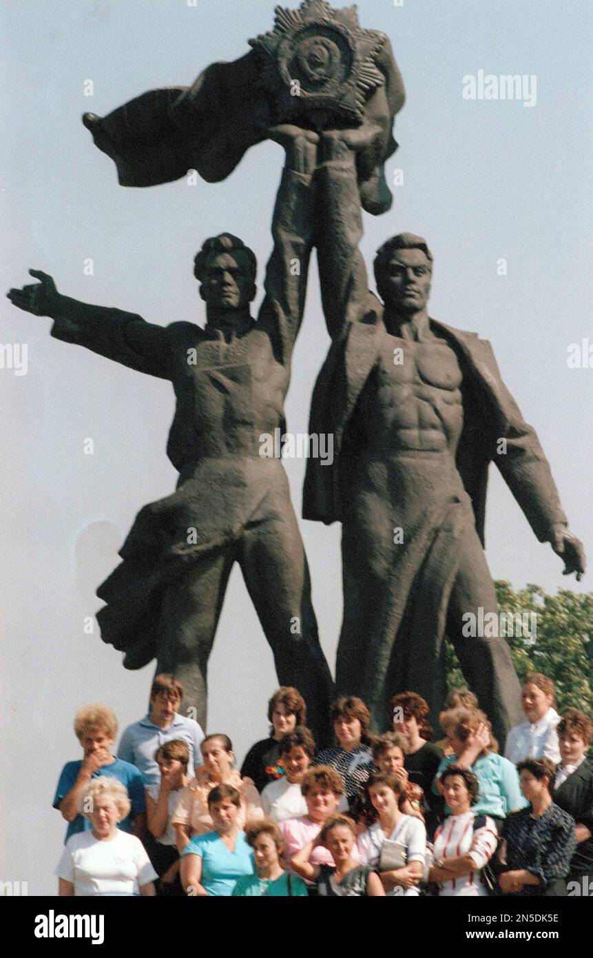 A group poses by the Statue of Friendship in Kiev, Ukraine, Sept. 5 ...