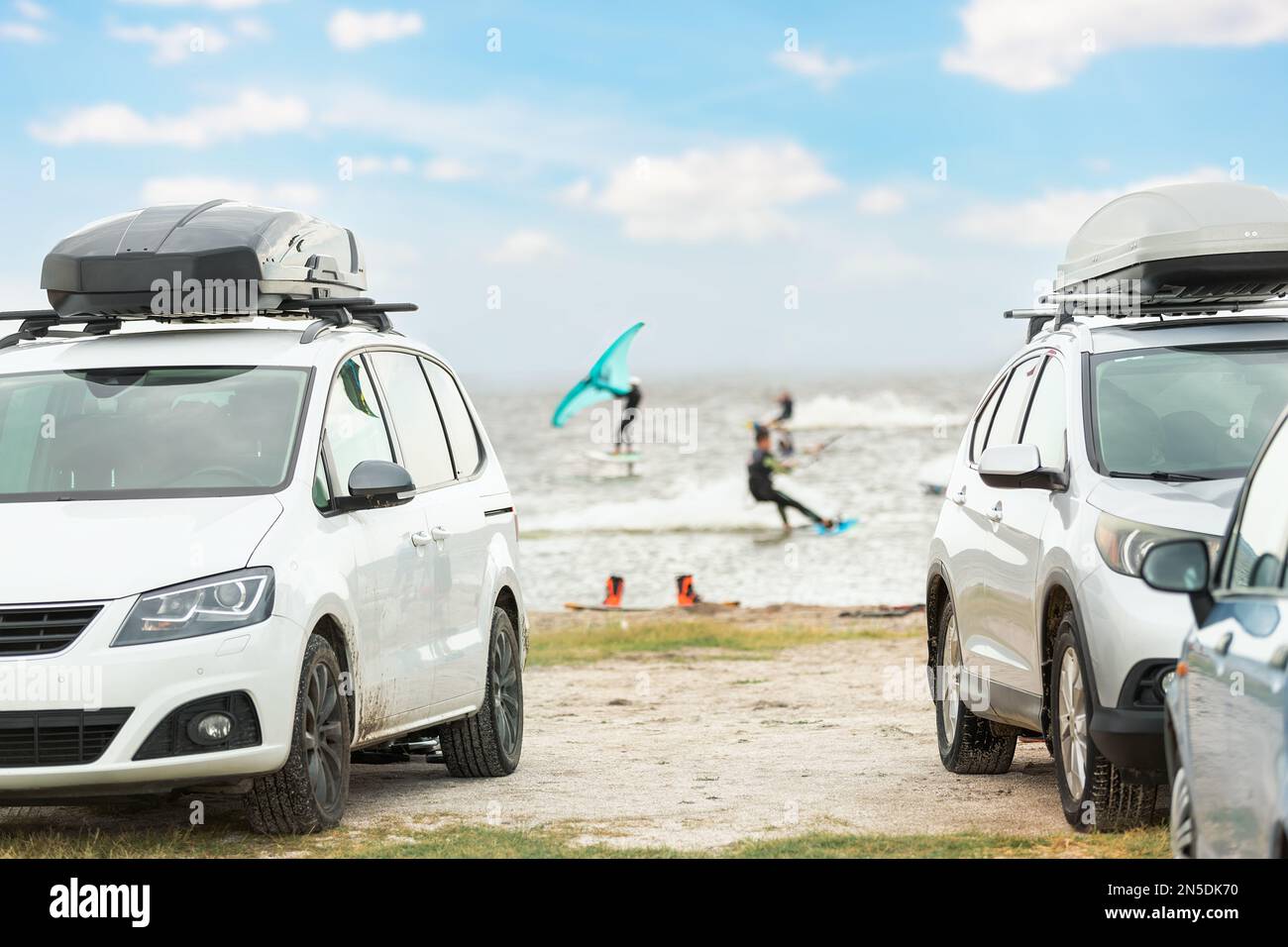 Front view many cars parked with surf board kite equipment on sand ...