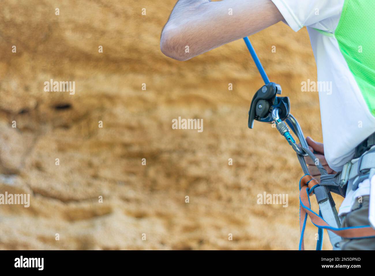 An alpinist tying a rope on his climbing equipment Stock Photo - Alamy