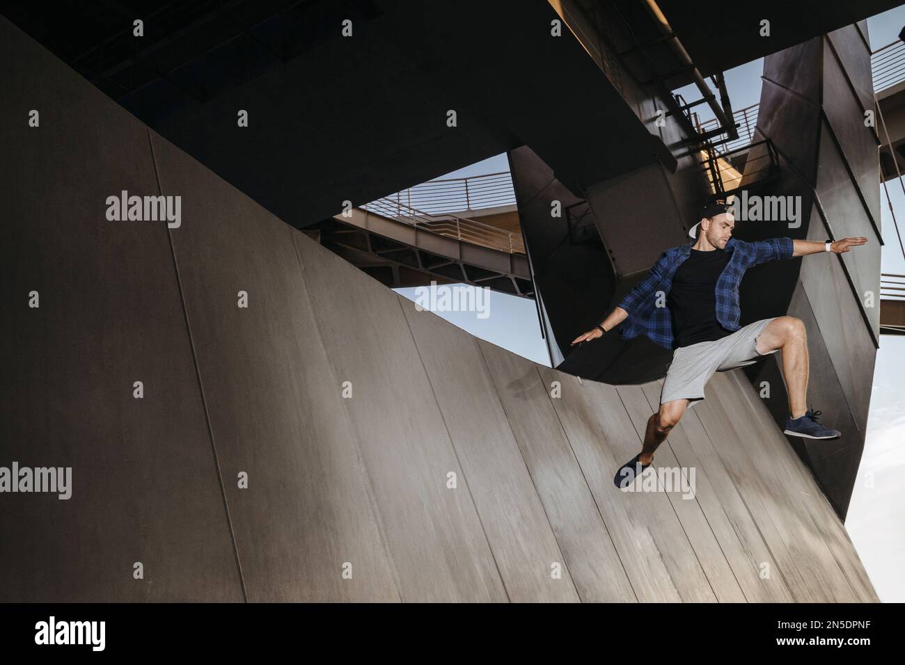 Parkour athlete jumping from the wall and flying. Man practicing ...