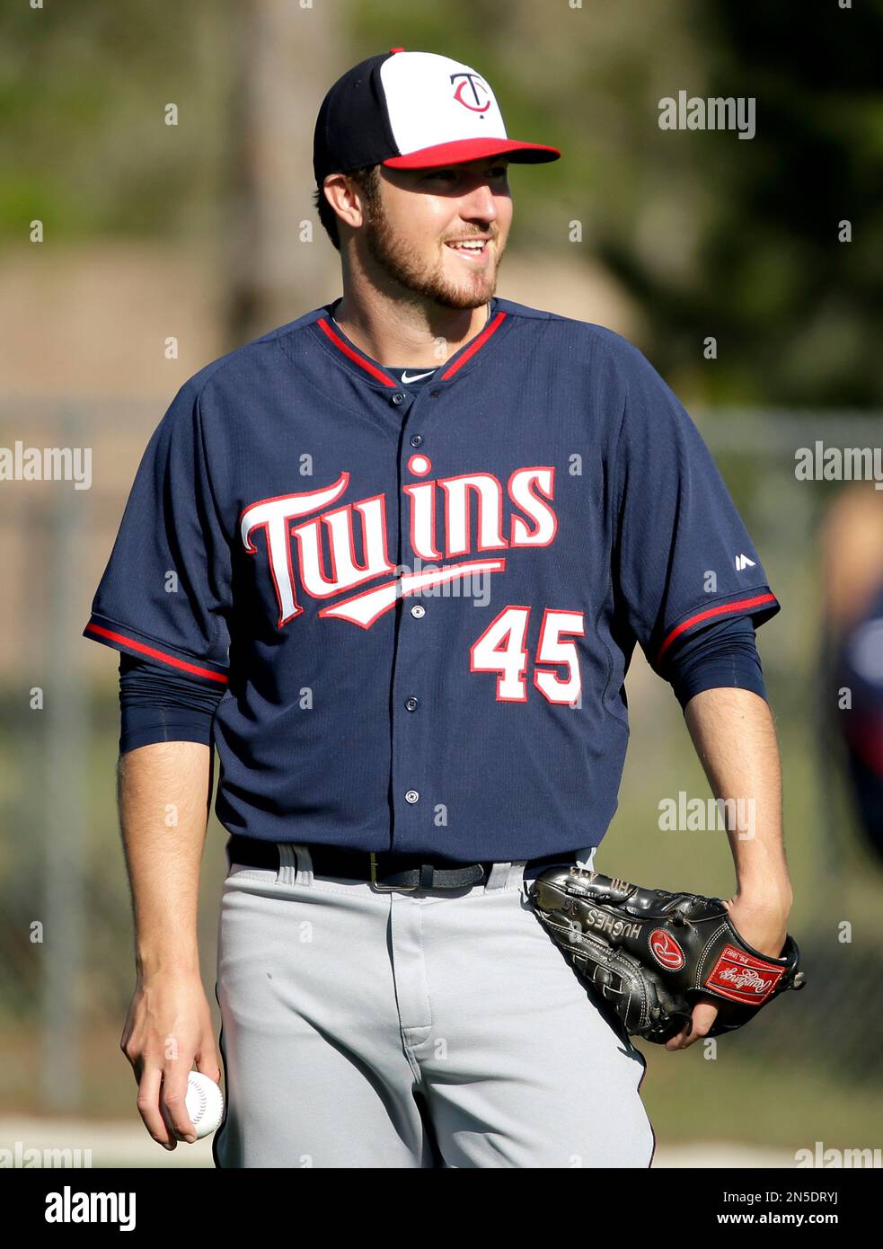Minnesota Twins pitcher Phil Hughes talks while warming up on the field ...