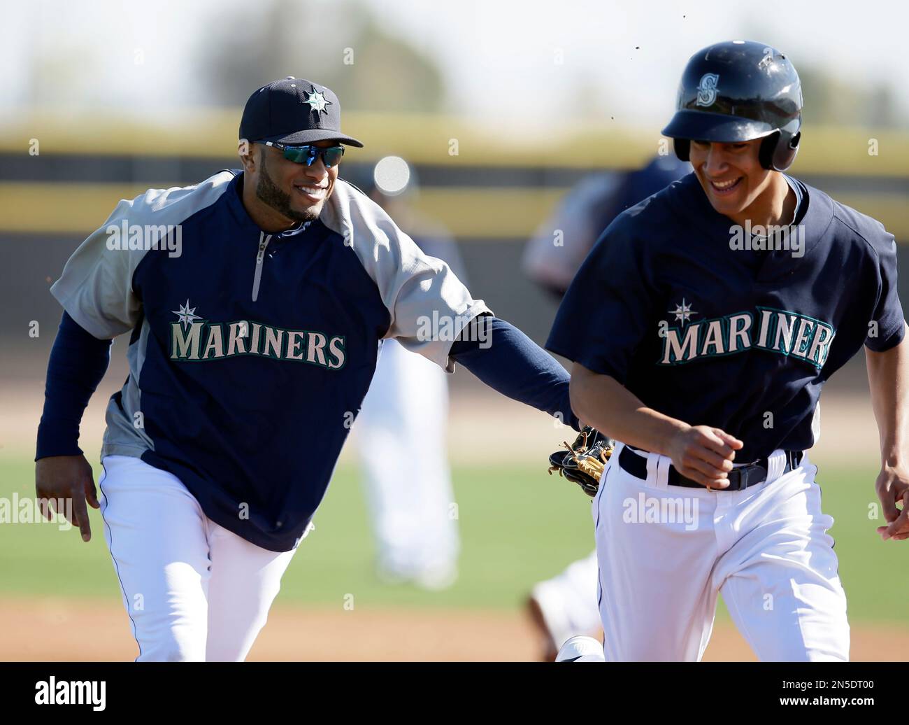 Seattle Mariners' Robinson Cano, left, chases down a teammate as they participate in fielding ...
