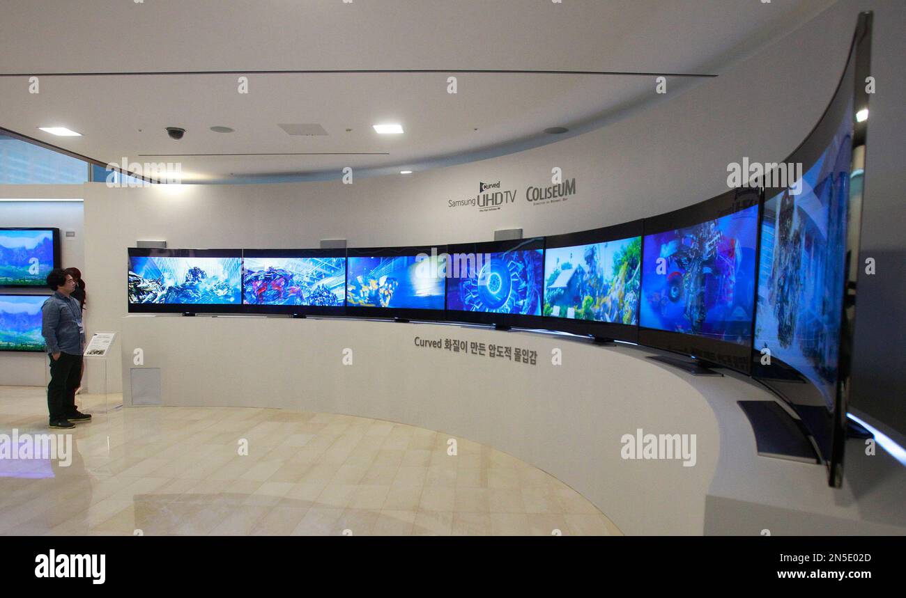 A journalist looks at Samsung Electronics curved UHD TVs during a press ...