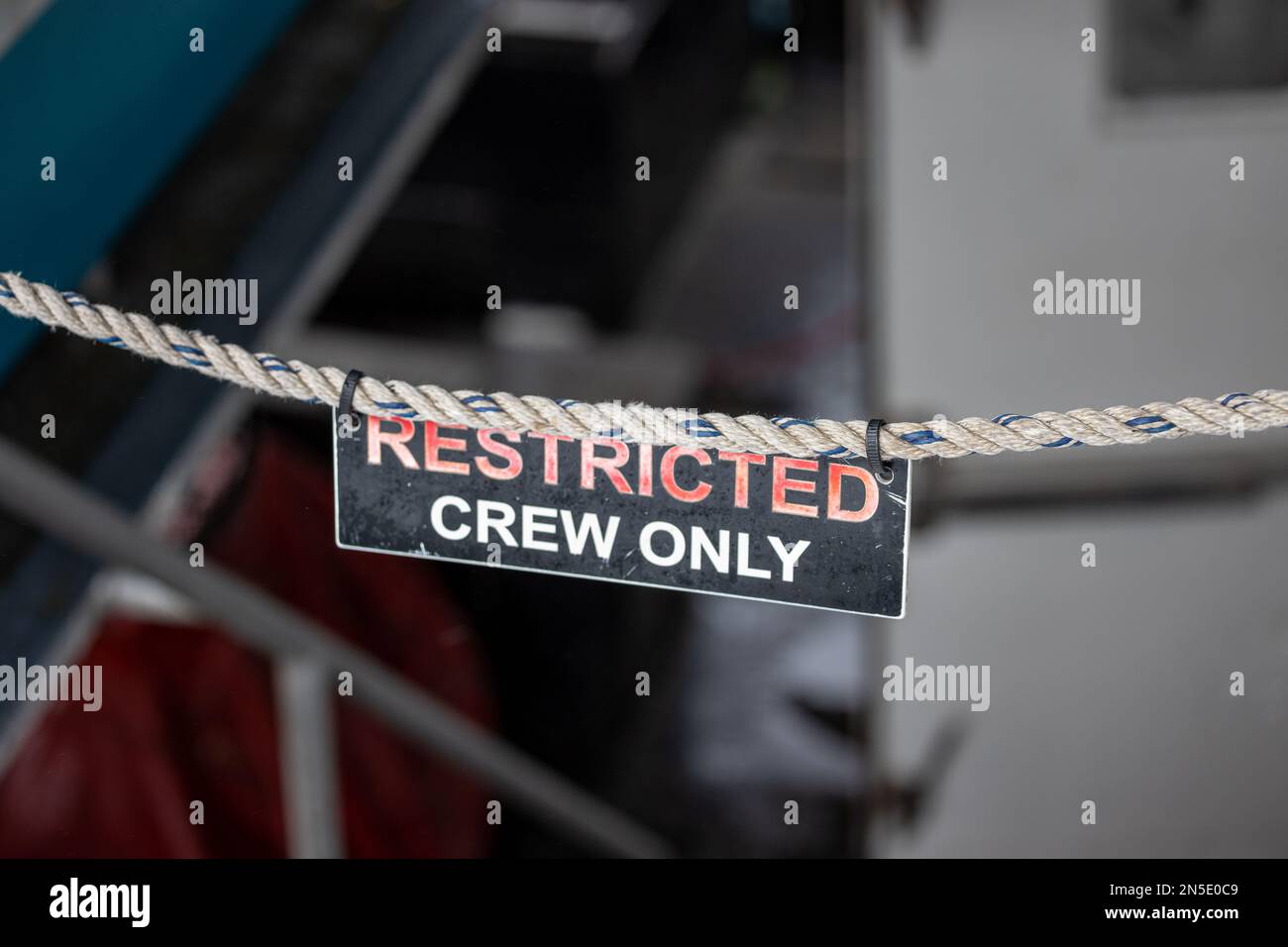 A black signage on the rope with the text "Restricted crew only Stock ...