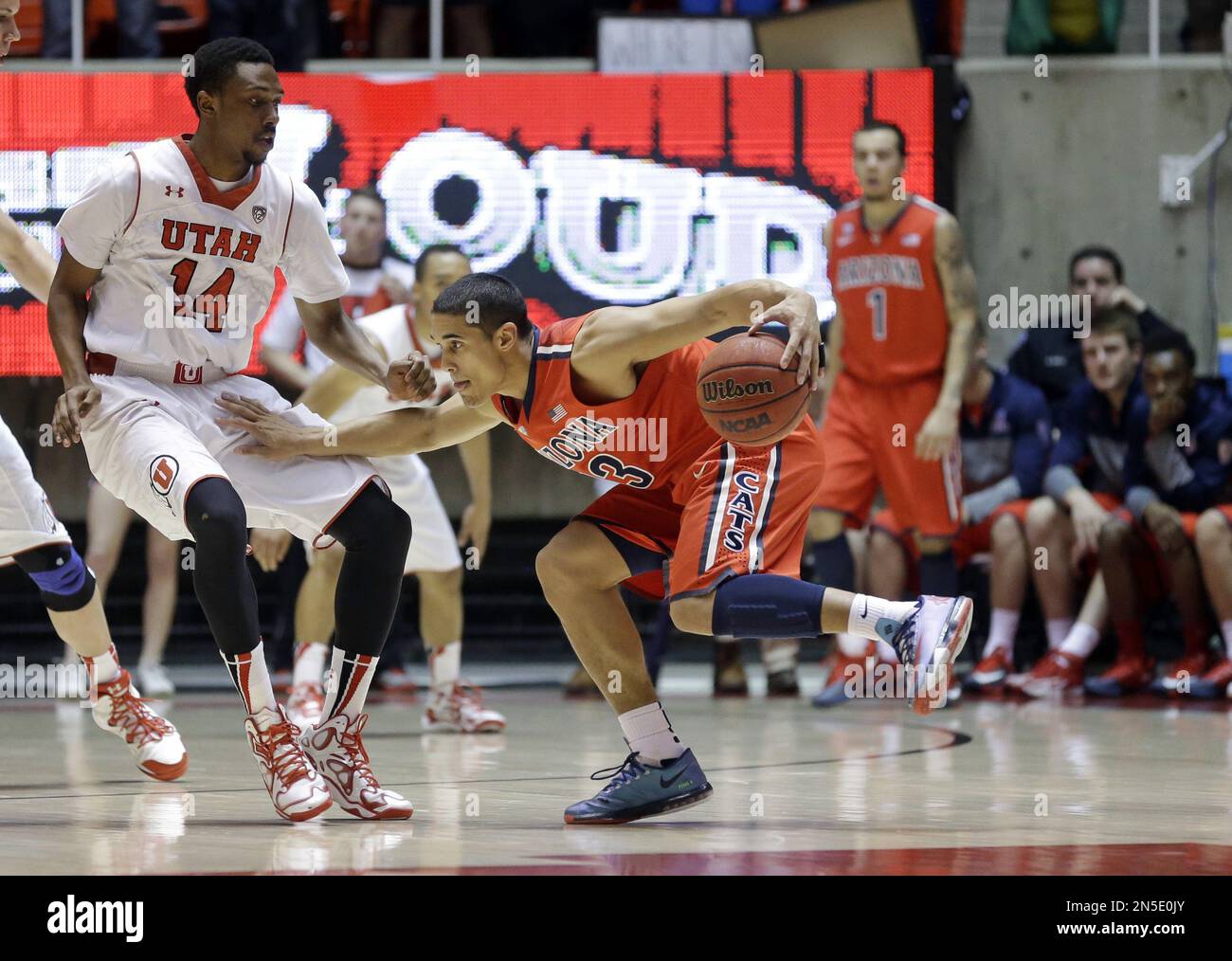Arizona's Nick Johnson (13) drives against Utah's Dakarai Tucker (14 ...