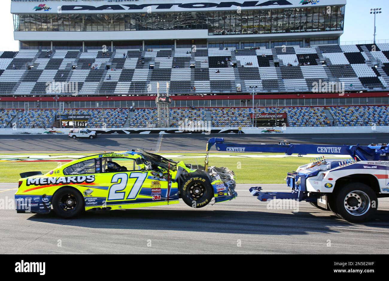 A wrecker tows Paul Menard's wrecked car after a crash during practice ...