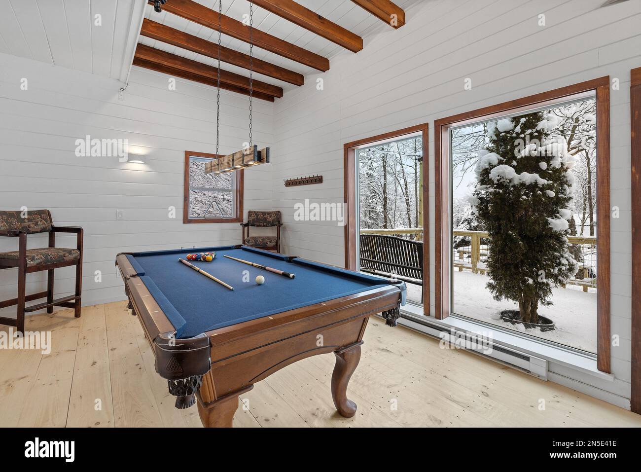 A large pool table in a room next to a large window Stock Photo - Alamy