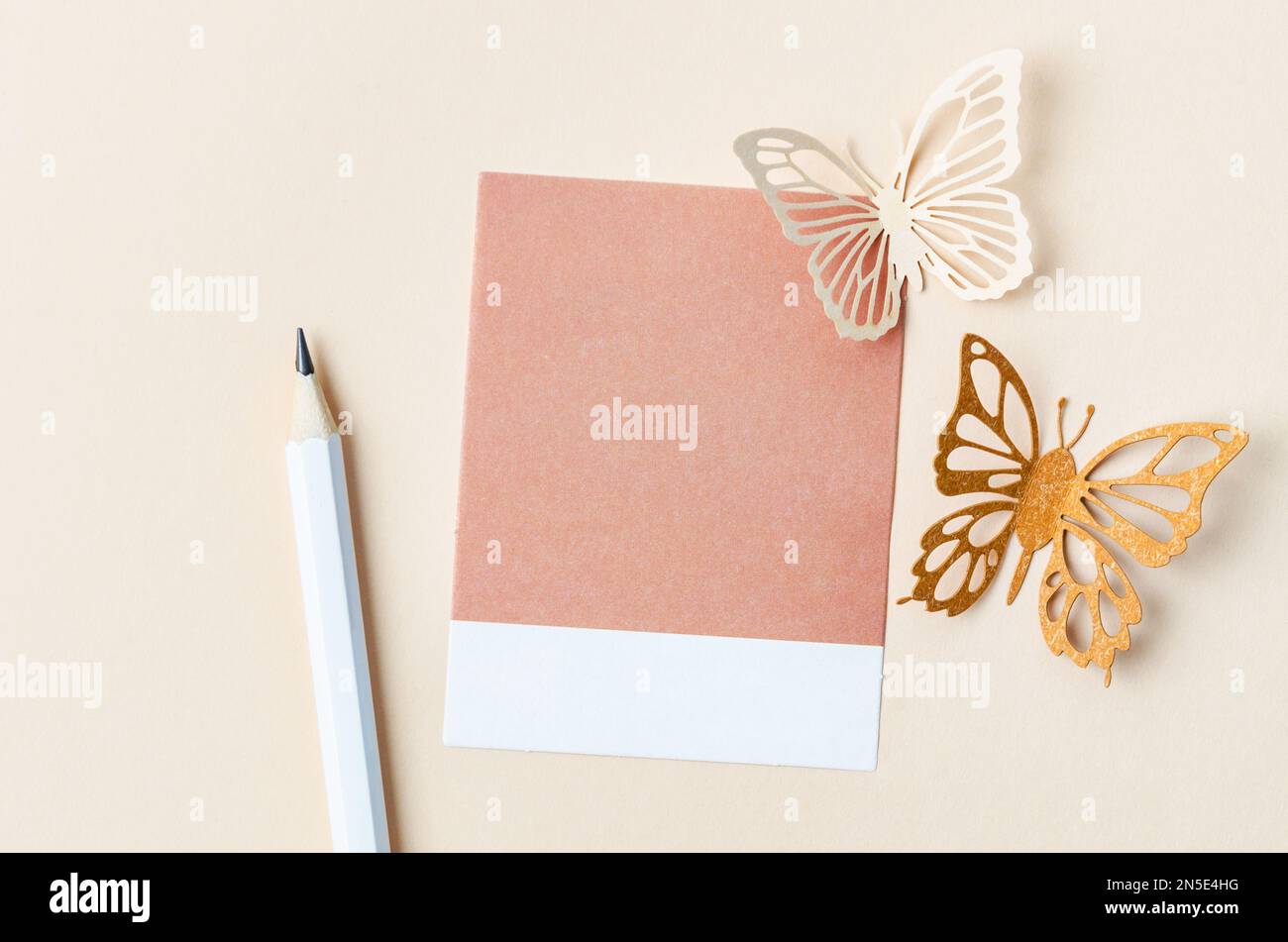 Blank reminder note and carve of paper butterfly with pencil on yellow ...