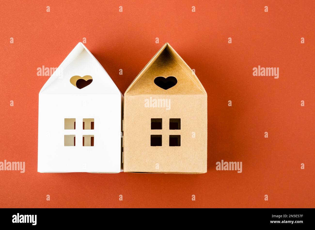 White and Brown paper house origami on red background with empty space ...