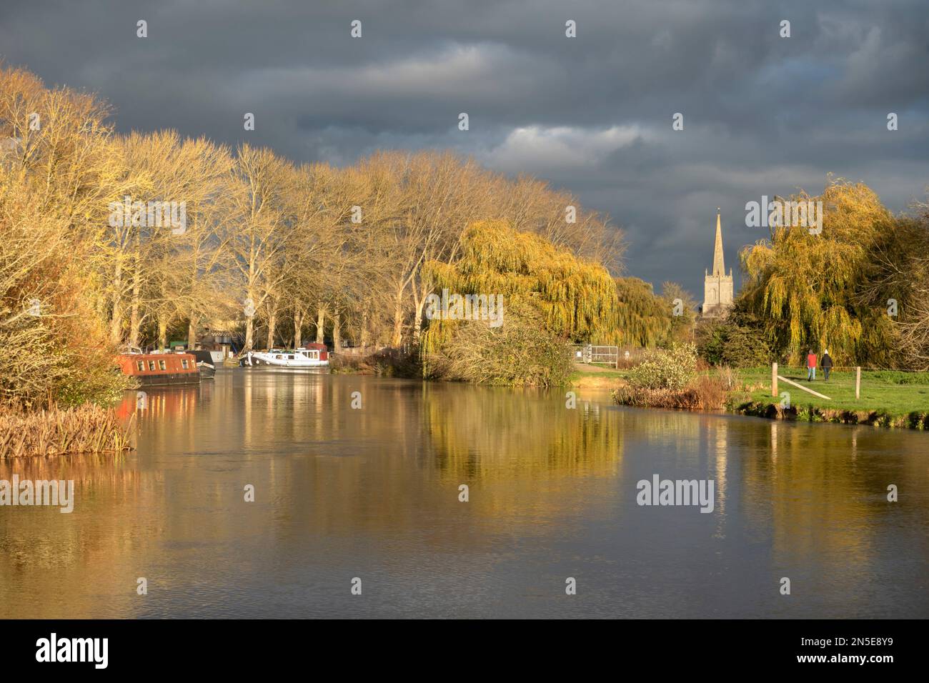 Spire of St Lawrence church beside the River Thames with autumn trees ...