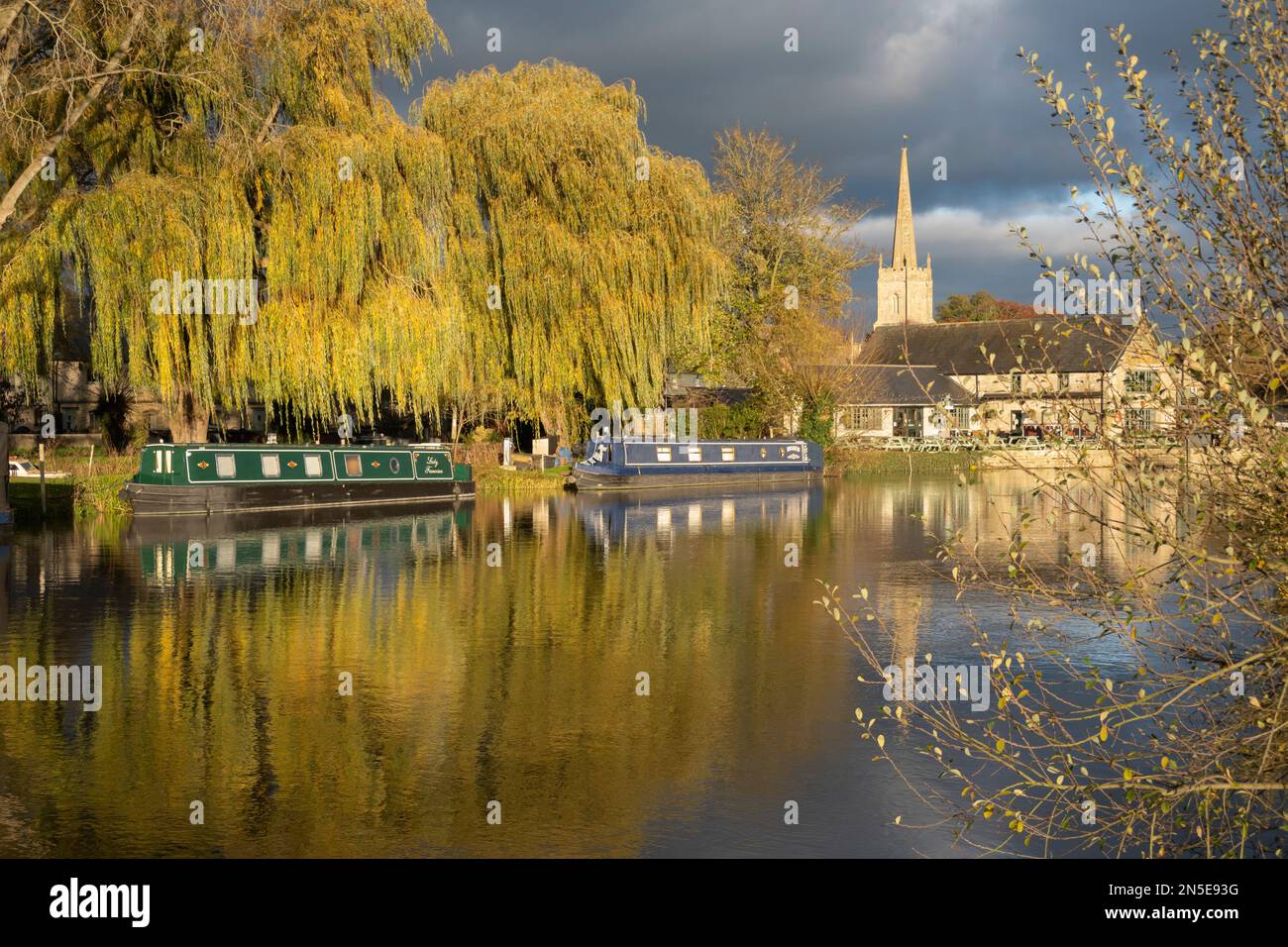 Spire of St Lawrence church beside the River Thames with autumn trees ...