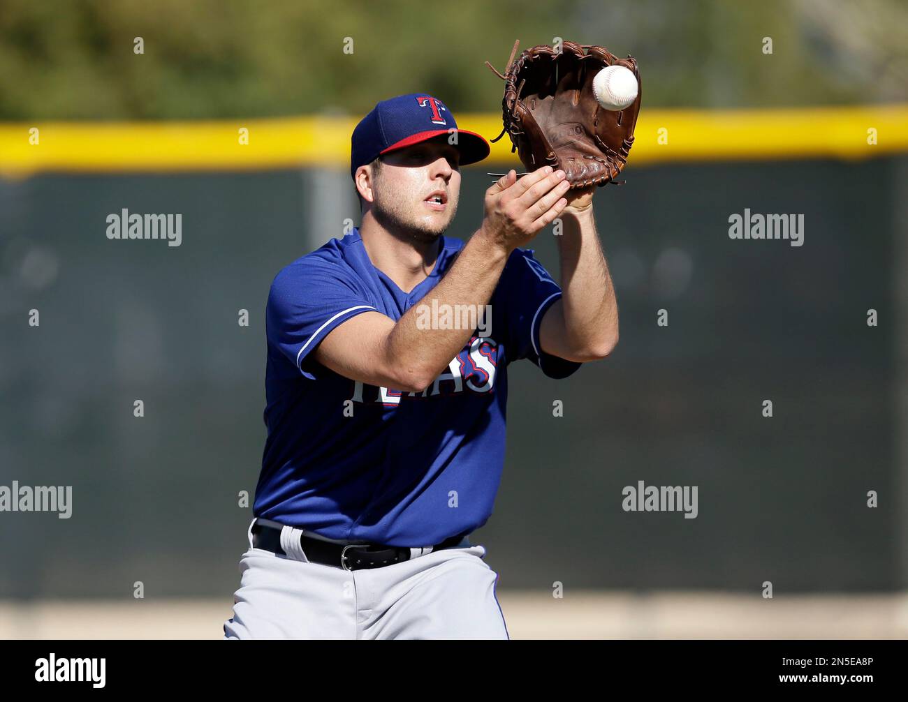 Texas Rangers pitcher Shawn Tolleson fields a ground ball during spring ...
