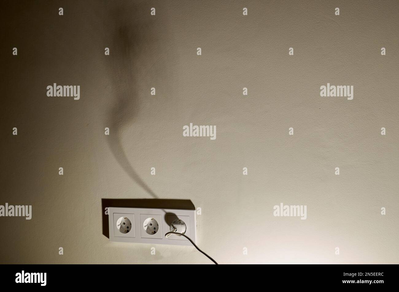 An electrical outlet and a smoke-like shadow from a wire. Electricity ...