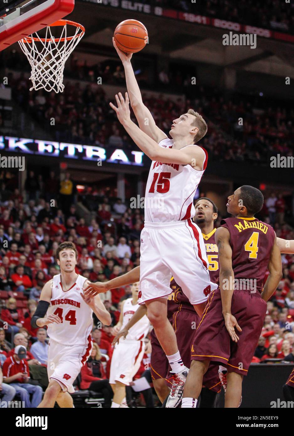 Wisconsin's Sam Dekker (15) shoots past Minnesota's Maurice Walker and ...