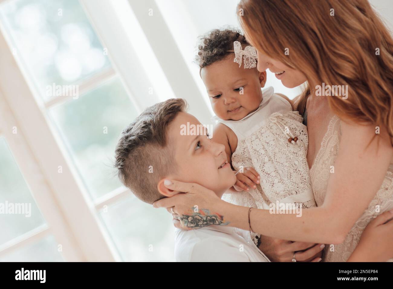 Mixed race family with white son and infant swarthy daughter spend time ...