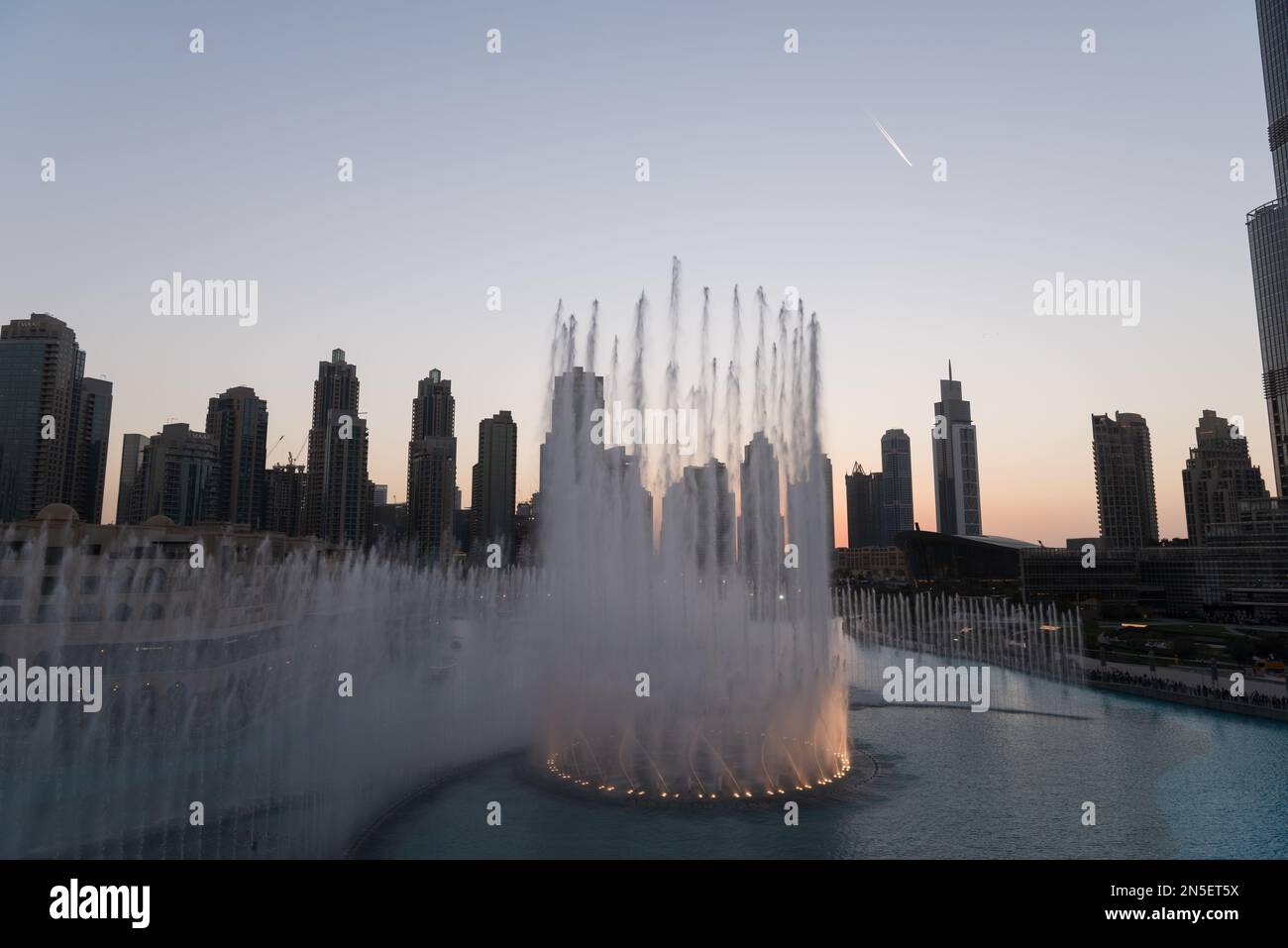 Dubai singing fountains at night lake view between skyscrapers. City ...