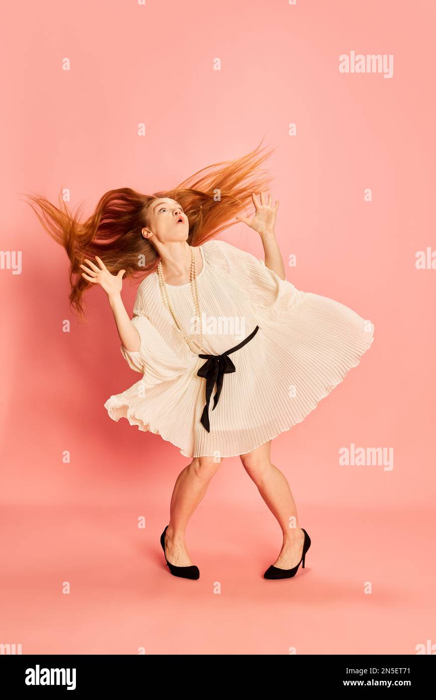 One young beautiful redhaired girl with long hair dancing, posing ...