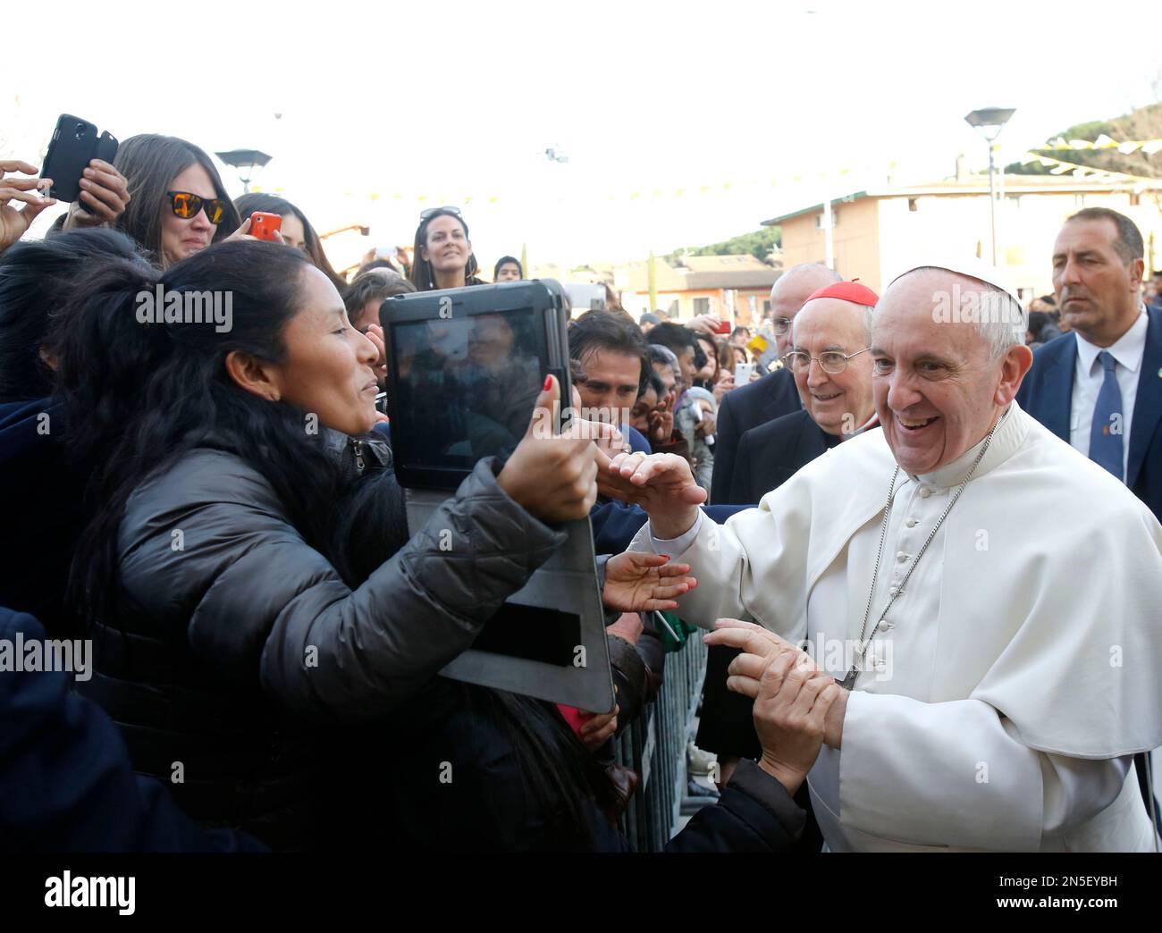 A woman holds up a tablet device as Pope Francis visits the San Tommaso ...