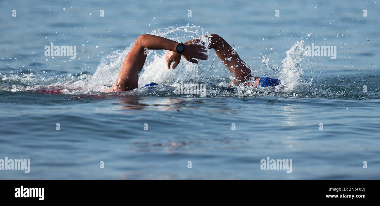Triathlon swimmers churning up the water two swimmers in races in ...
