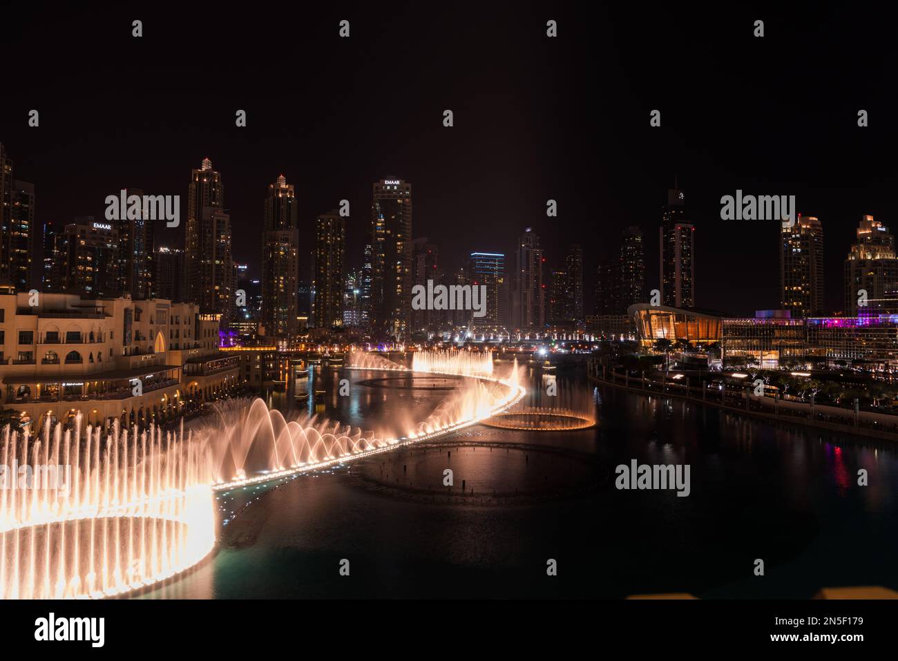 Dubai singing fountains at night lake view between skyscrapers. City ...