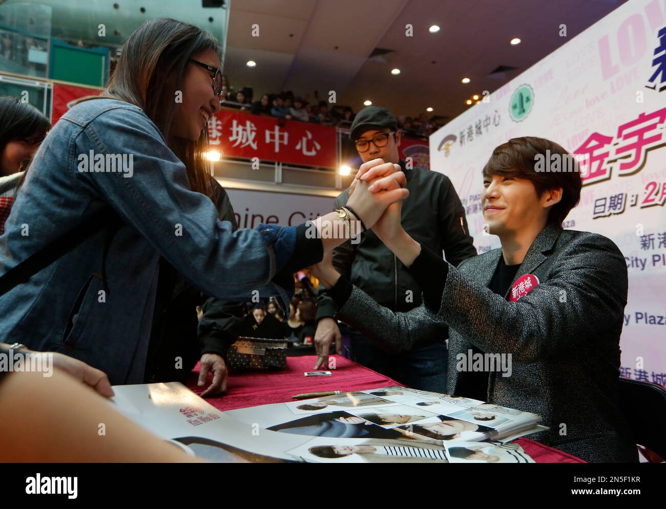 South Korean actor and model Kim Woo Bin shakes hands with a fan as he ...