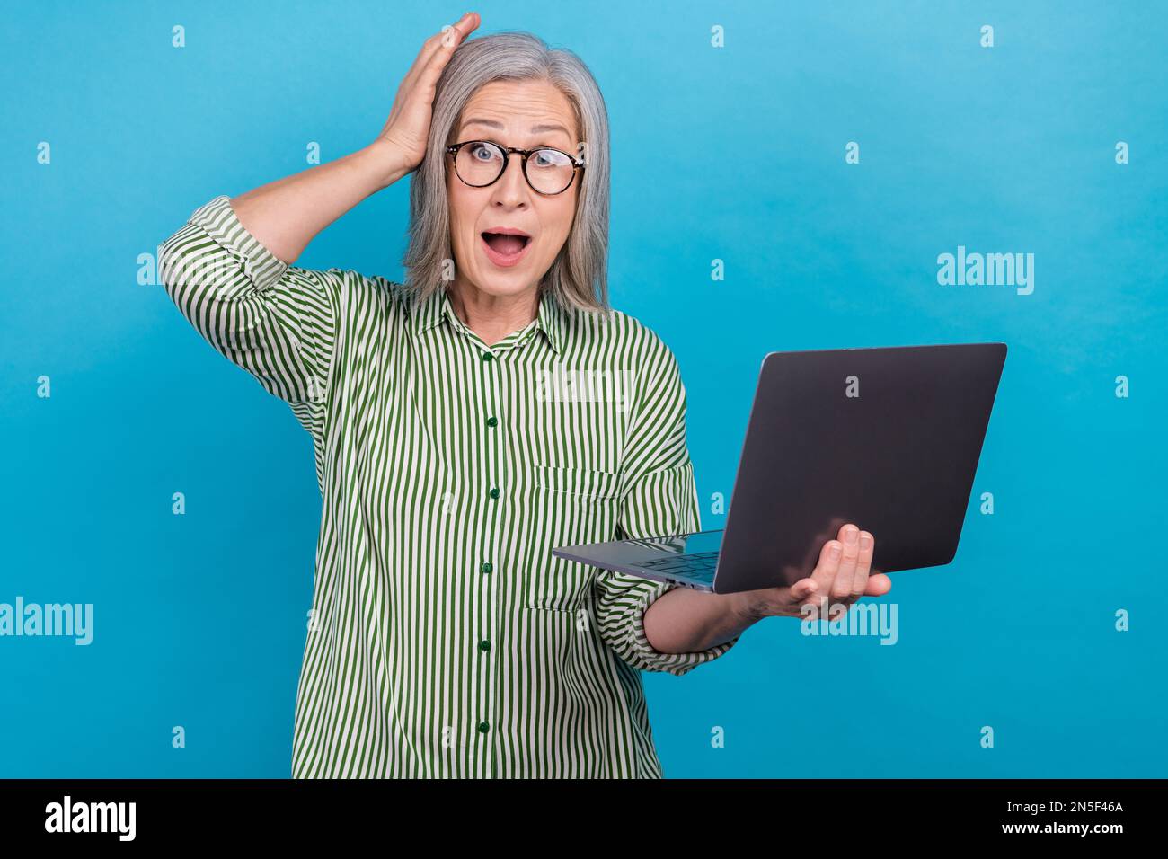 Photo of impressed speechless person hand touch head open mouth hold ...