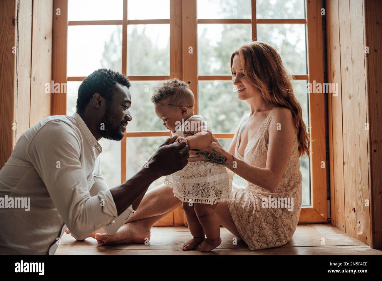 Mixed race family with dark skinned infant daughter spend time together ...