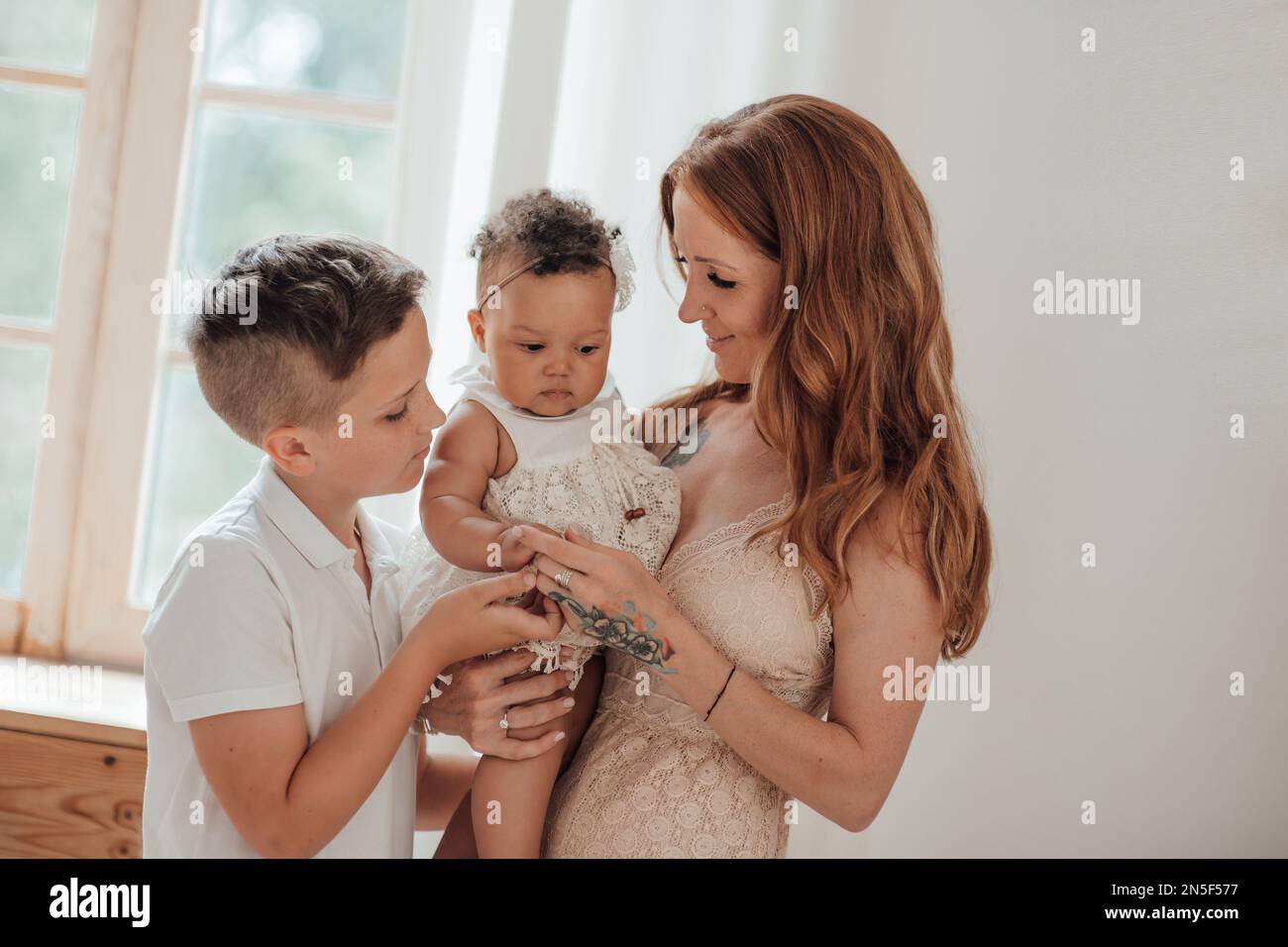 Mixed race family with white son and infant swarthy daughter spend time ...