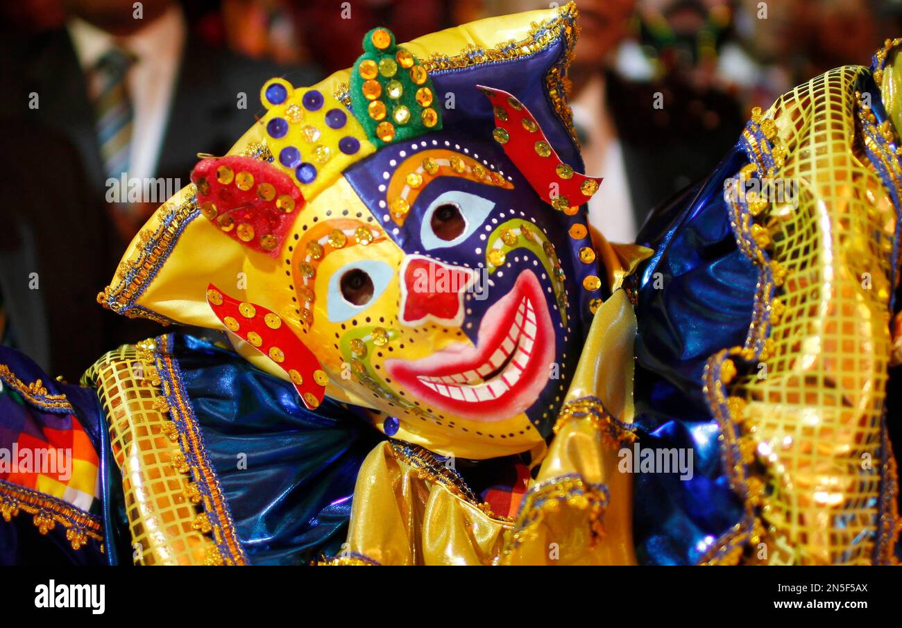 A man dressed as the Carnival character Pepino poses for photos while ...