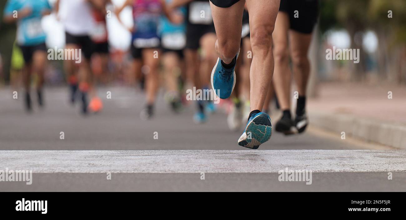 Marathon runners running on city road, large group of runners Stock ...