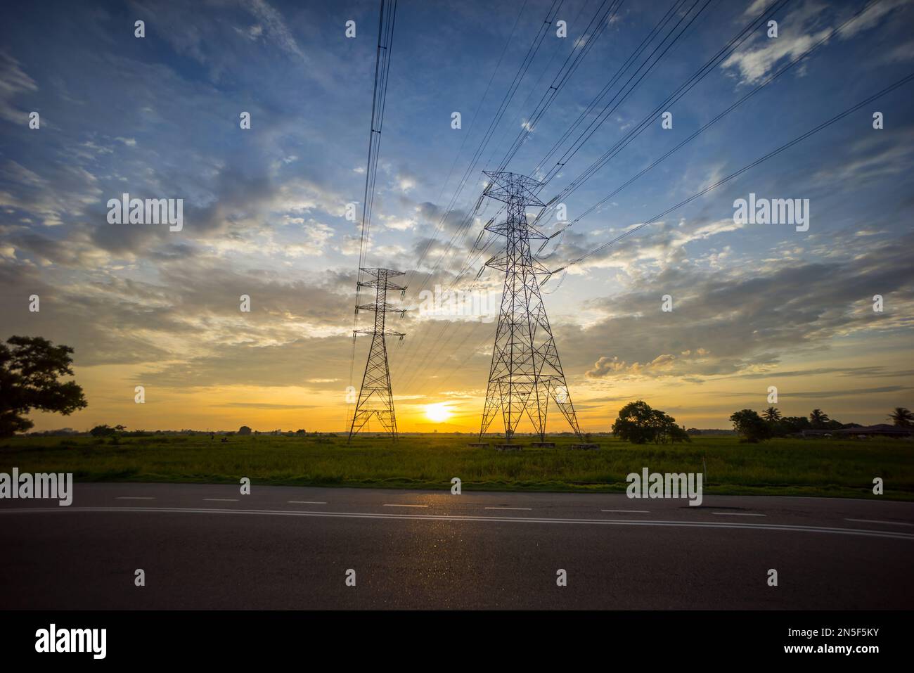 A tall electric post with a golden sunset background Stock Photo - Alamy