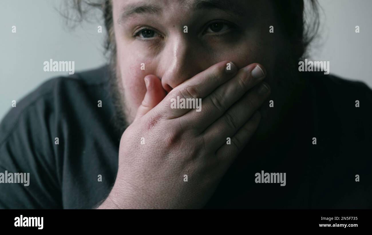 Preoccupied man suffering from mental pain. Close up face of a worried ...