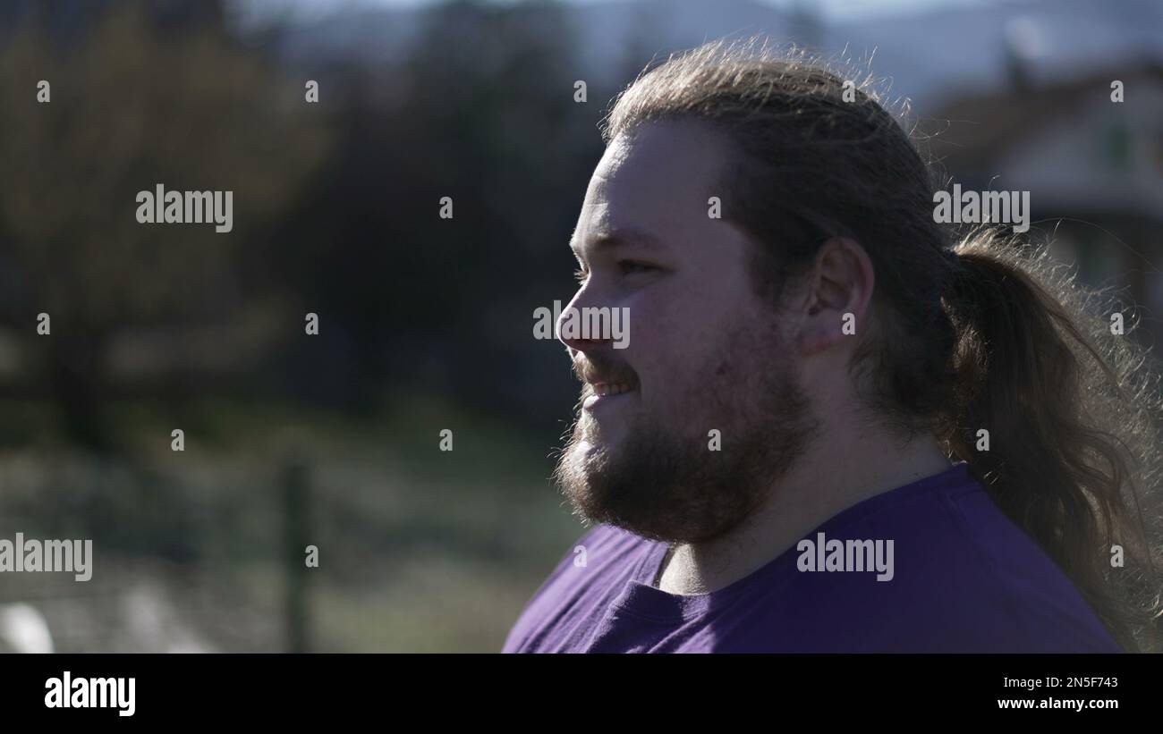 Positive overweight man walking outside exercising. A fat positive ...