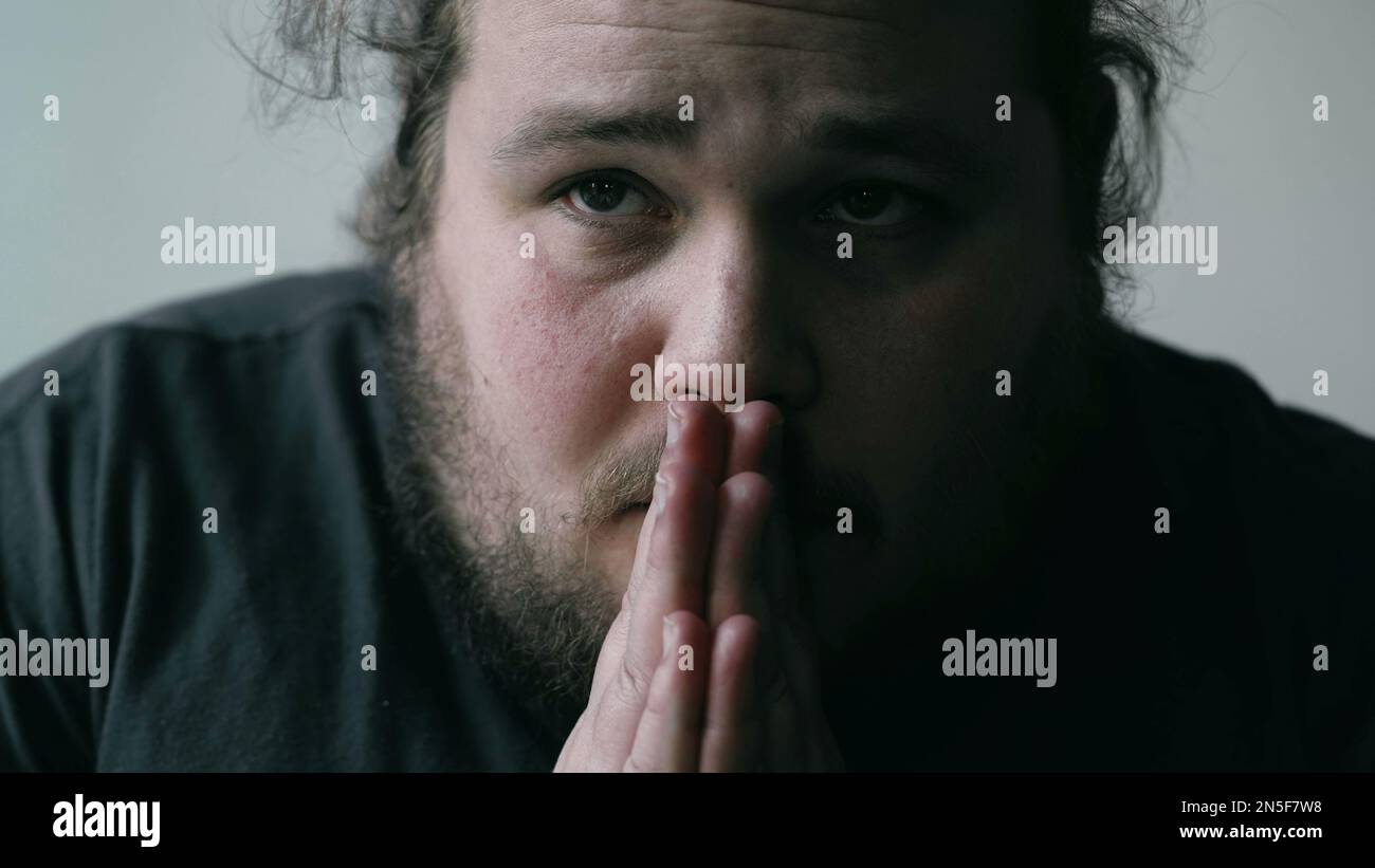 Preoccupied man suffering from mental pain. Close up face of a worried ...