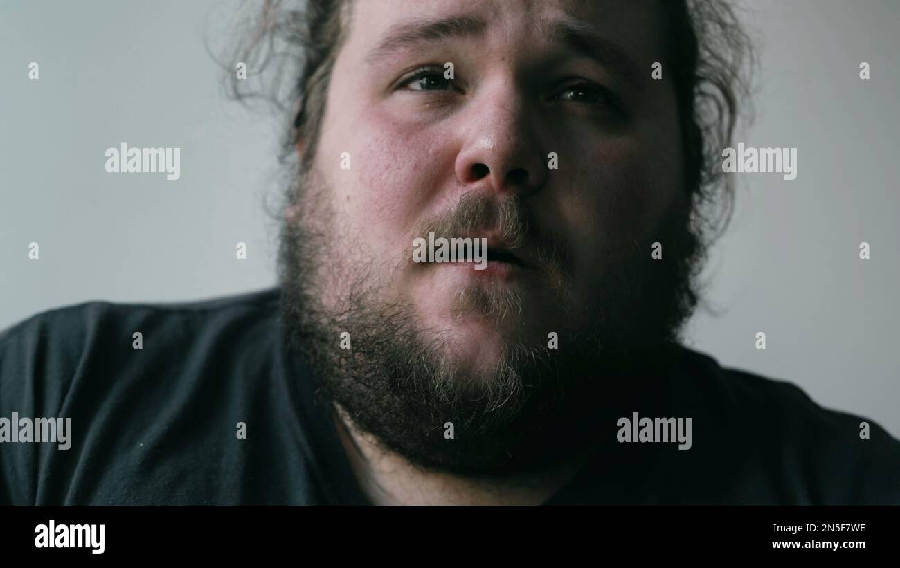 Preoccupied man suffering from mental pain. Close up face of a worried ...