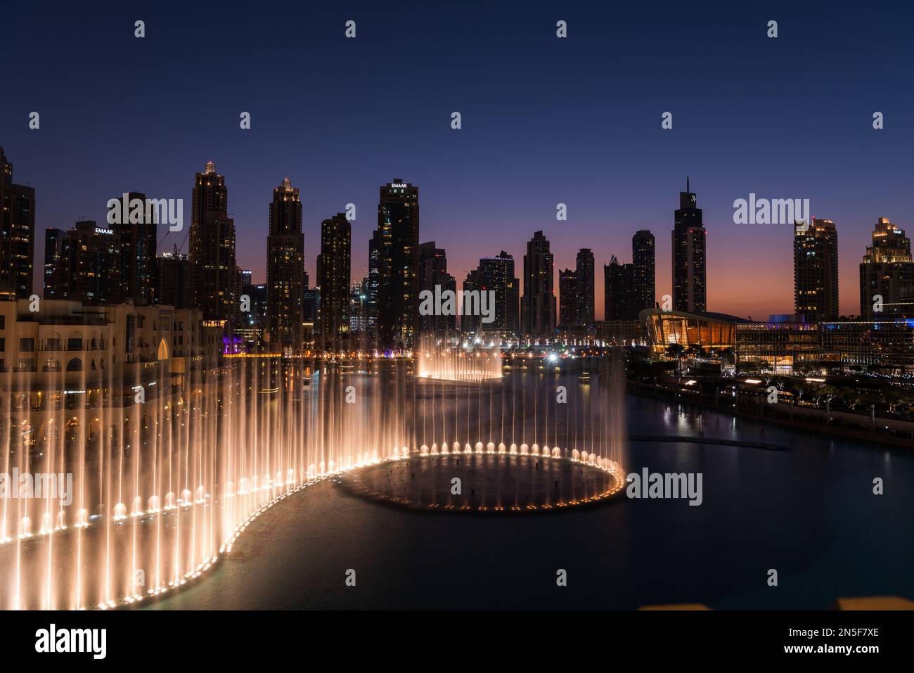 Dubai singing fountains at night lake view between skyscrapers. City ...